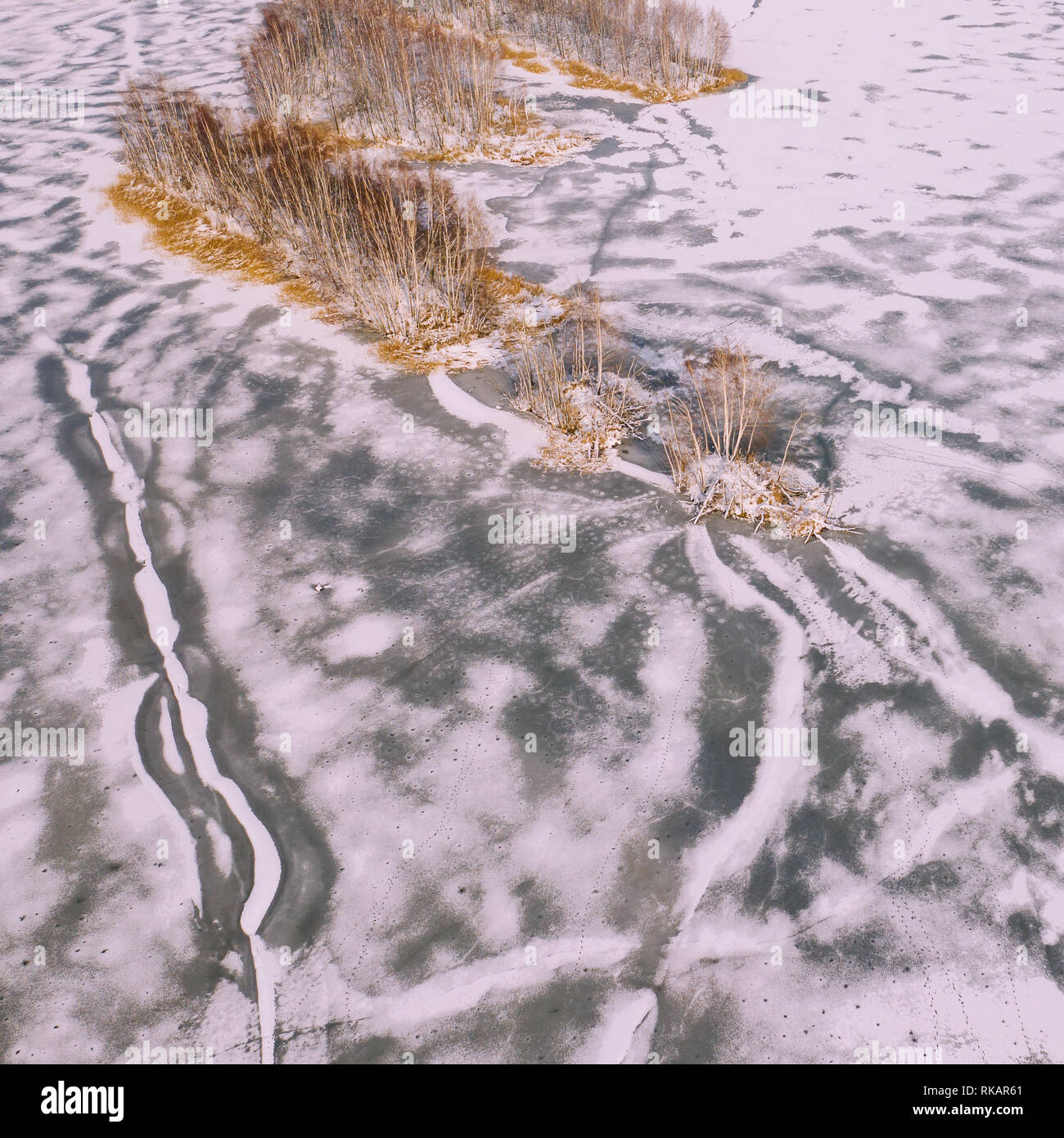 Aerial view of the winter snow covered forest and frozen lake from ...