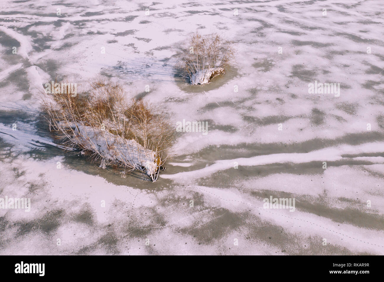 Aerial view of the winter snow covered forest and frozen lake from ...