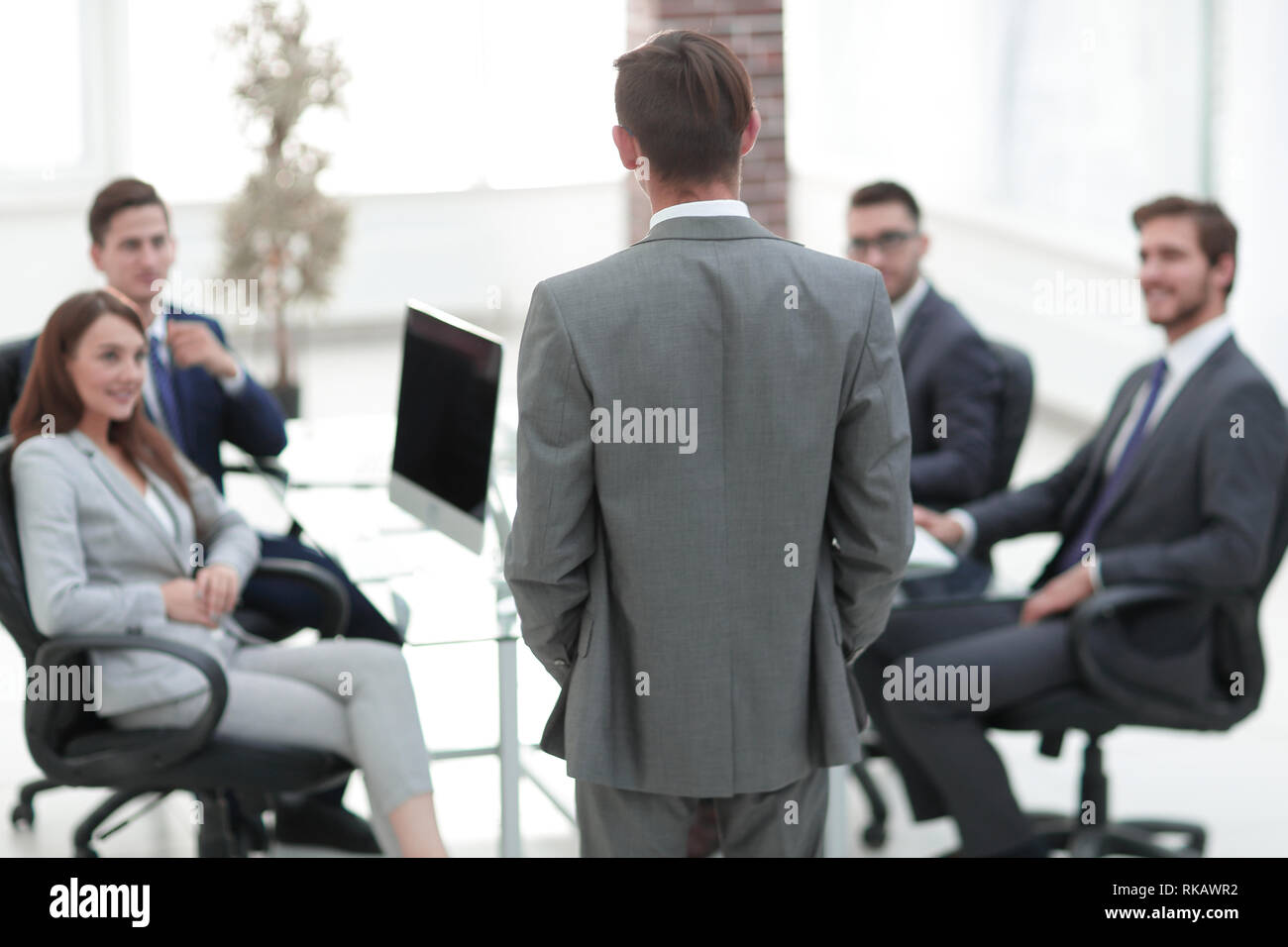 Rear view portrait of man giving business presentation to colleagues in ...
