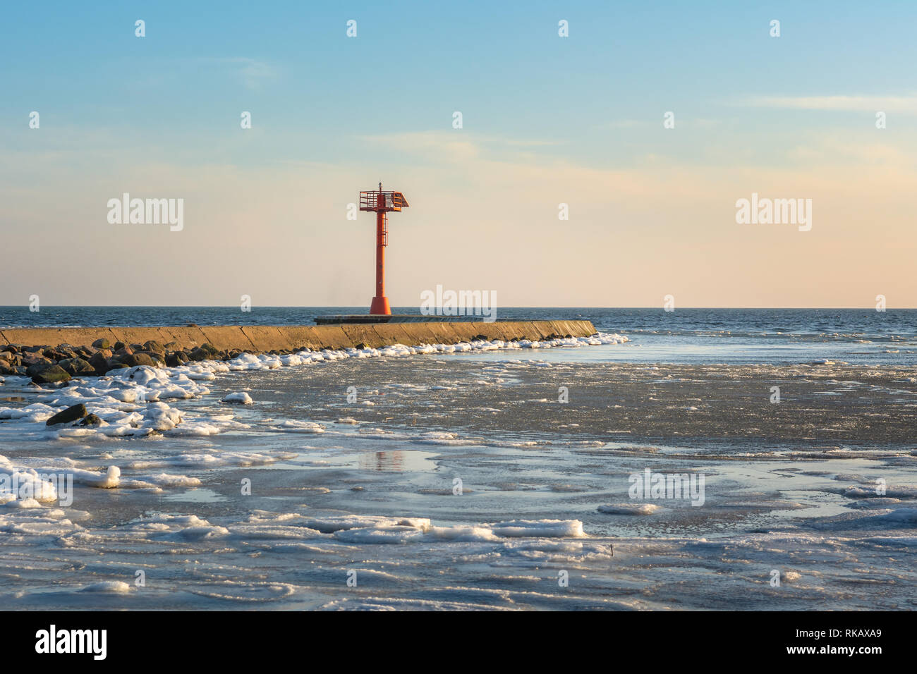 The Baltic Sea and a lighthouse in the port of Jastarnia in the winter ...