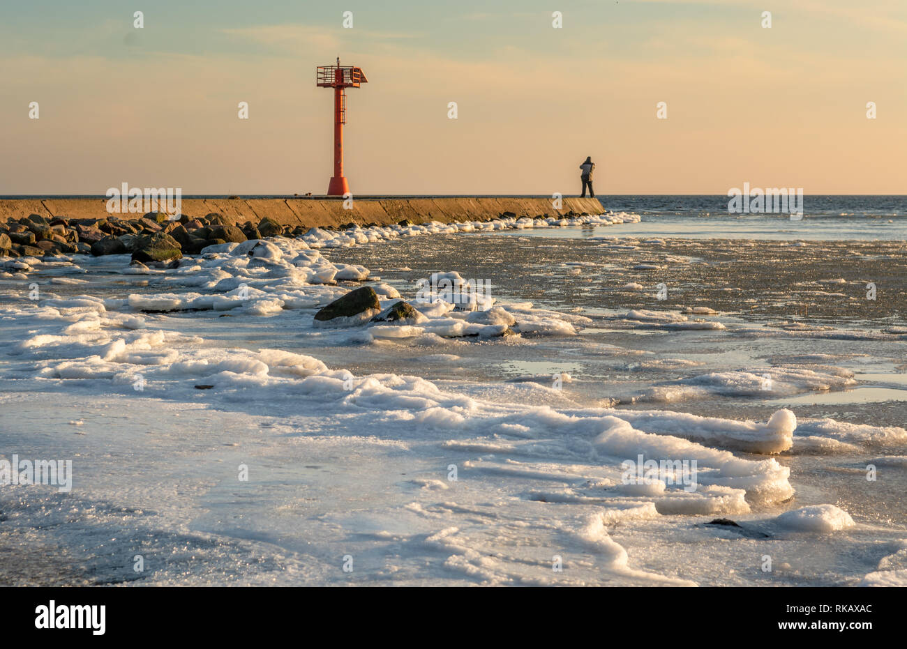 The Baltic Sea and a lighthouse in the port of Jastarnia in the winter ...