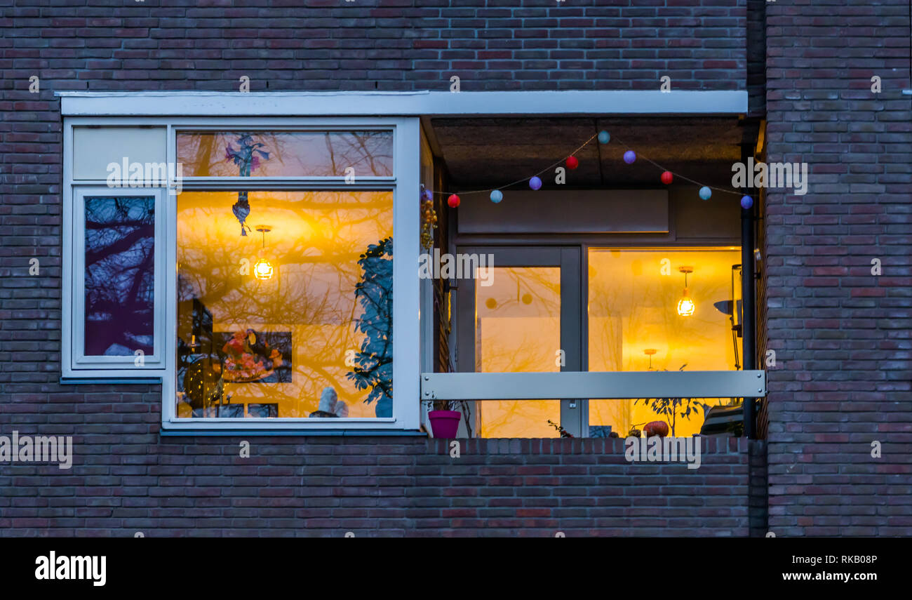 apartment with lighted windows and a balcony, Dutch city architecture ...