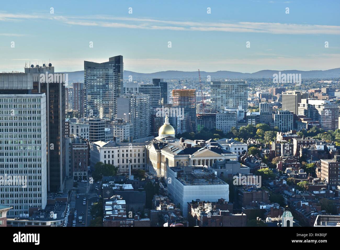 The gold dome of the Massachusetts State House atop Beacon Hill against ...