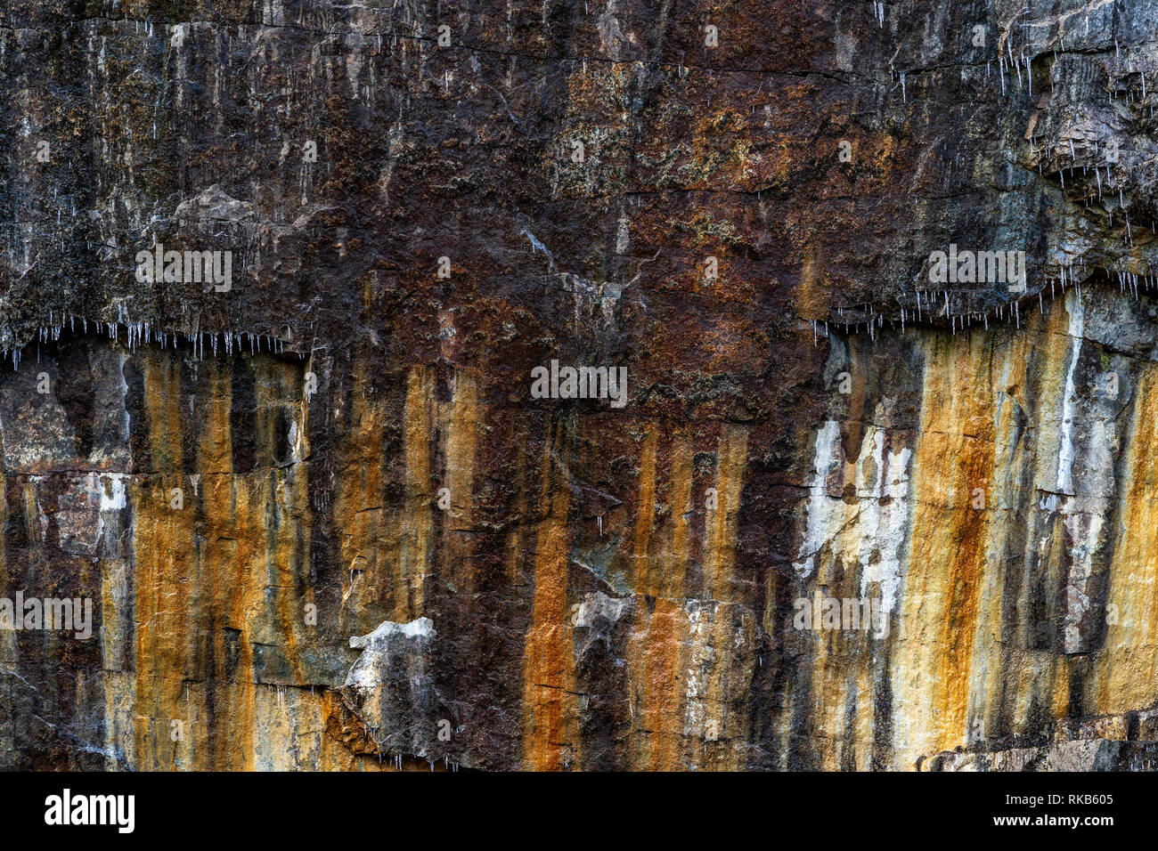 Rustic stone quarry with heavy rust patterns, cracks and icicles - high ...