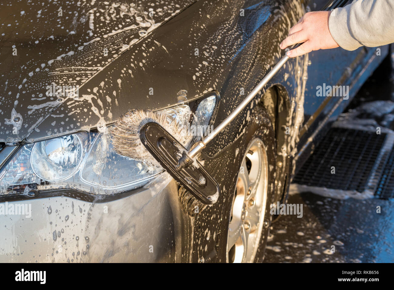 Washing the car using a brush in a self-service car wash Stock Photo ...