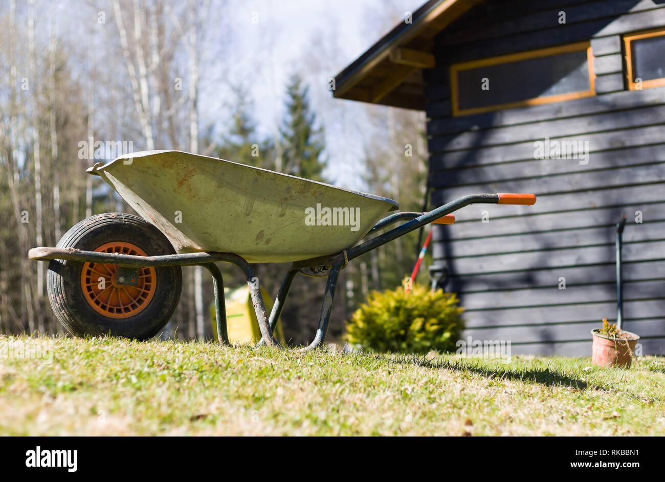 Work in garden wheelbarrow on the front of farm house Stock Photo - Alamy