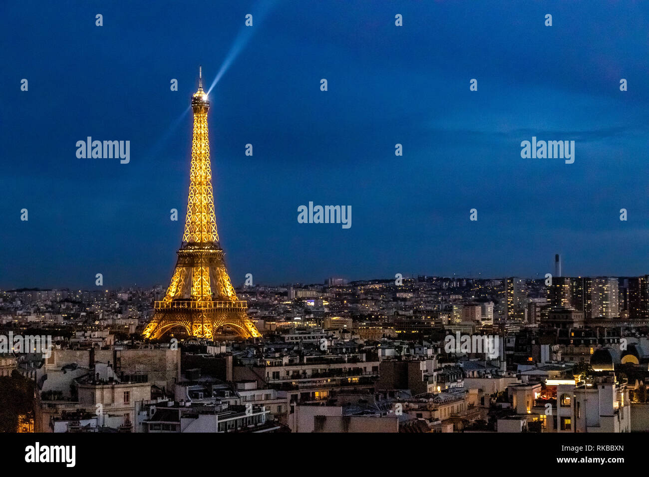 The Eiffel Tower illuminated at night as seen from the Top Of The Arc de Triomphe de l'Étoile on ...