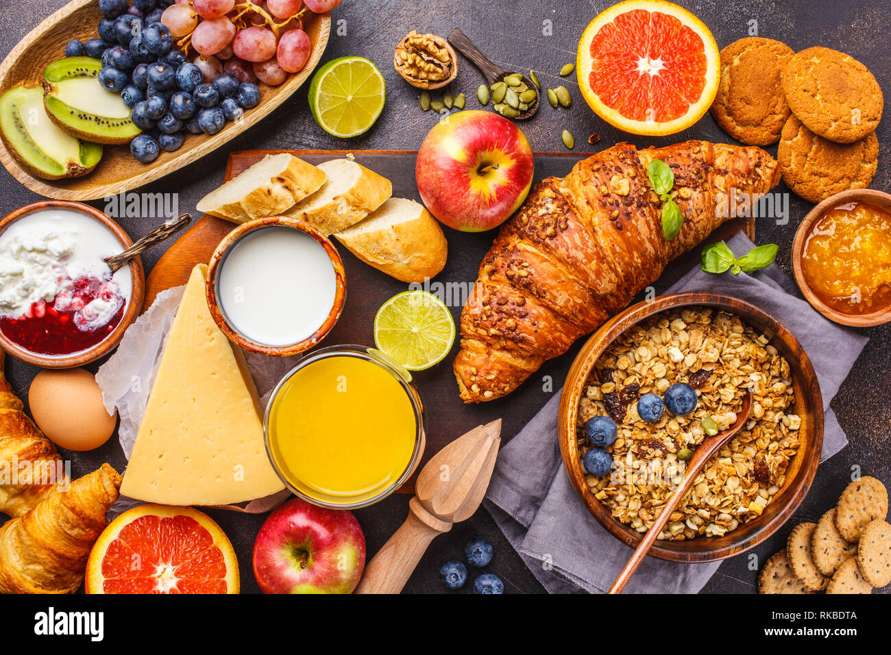 Healthy balanced breakfast on a dark background. Muesli, milk, juice ...
