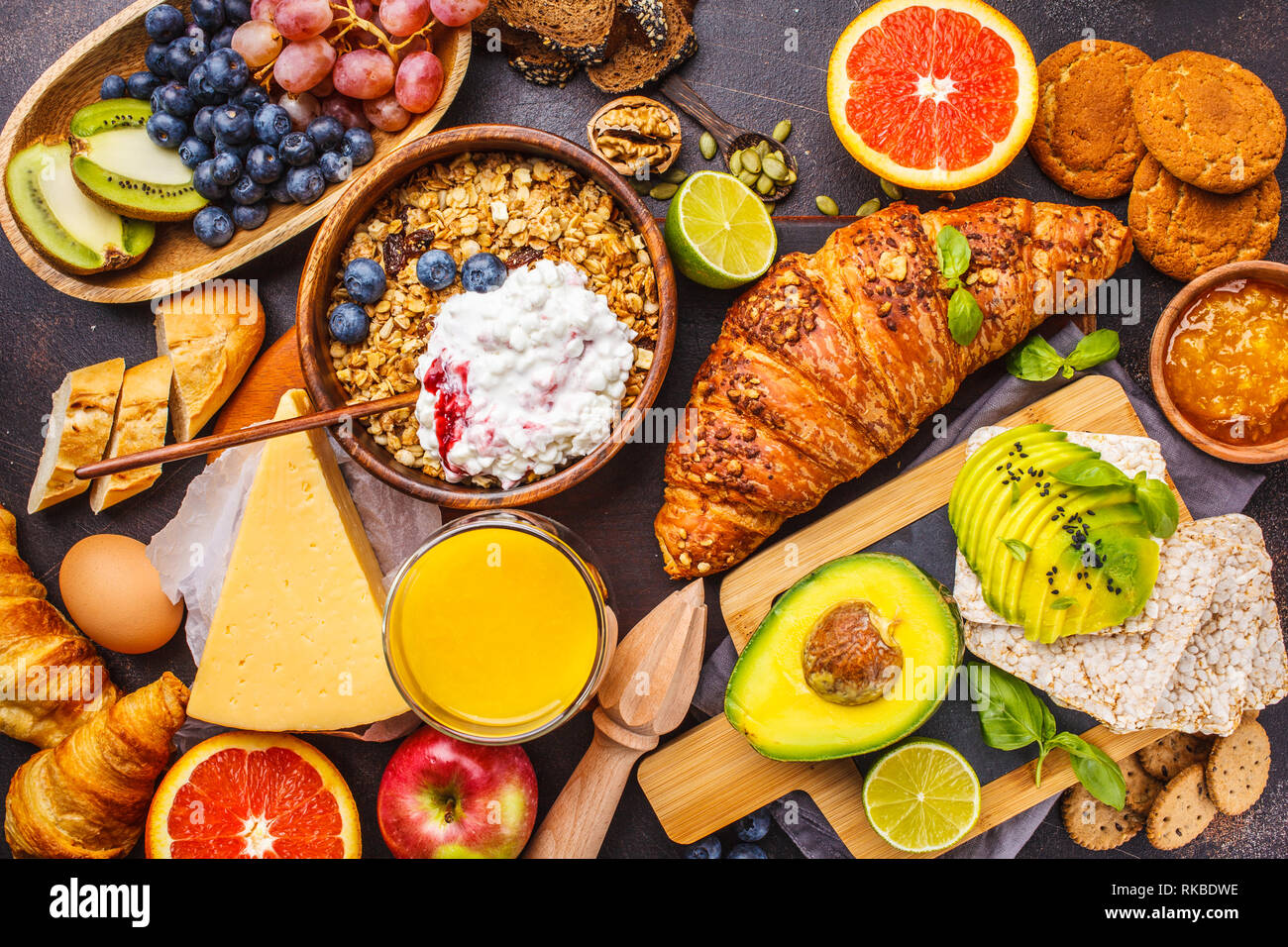 Healthy balanced breakfast on a dark background. Muesli, milk, juice ...