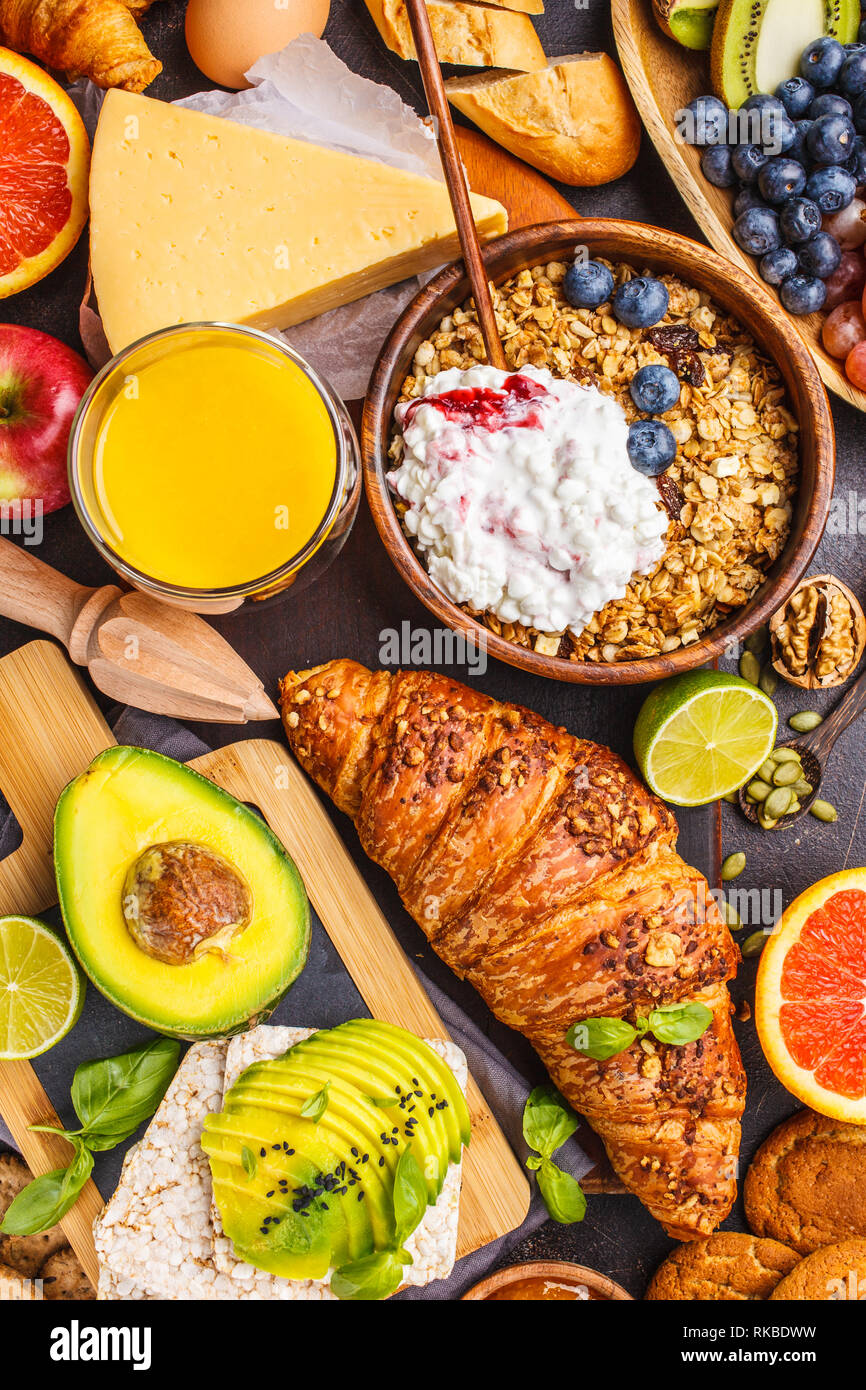 Healthy balanced breakfast on a dark background. Muesli, milk, juice ...