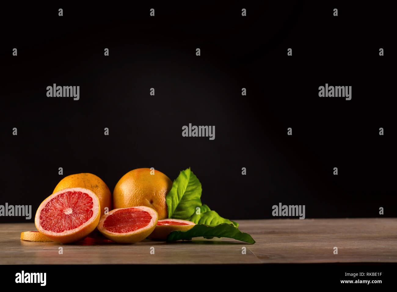 grapefruit on wooden table with black background Stock Photo - Alamy