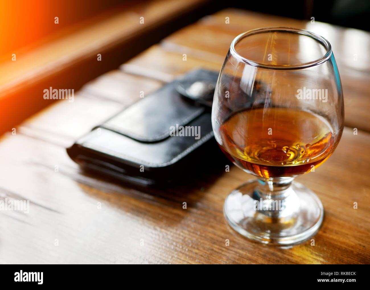 Leather wallet, red wine glass and cash spread out a table, concept of ...