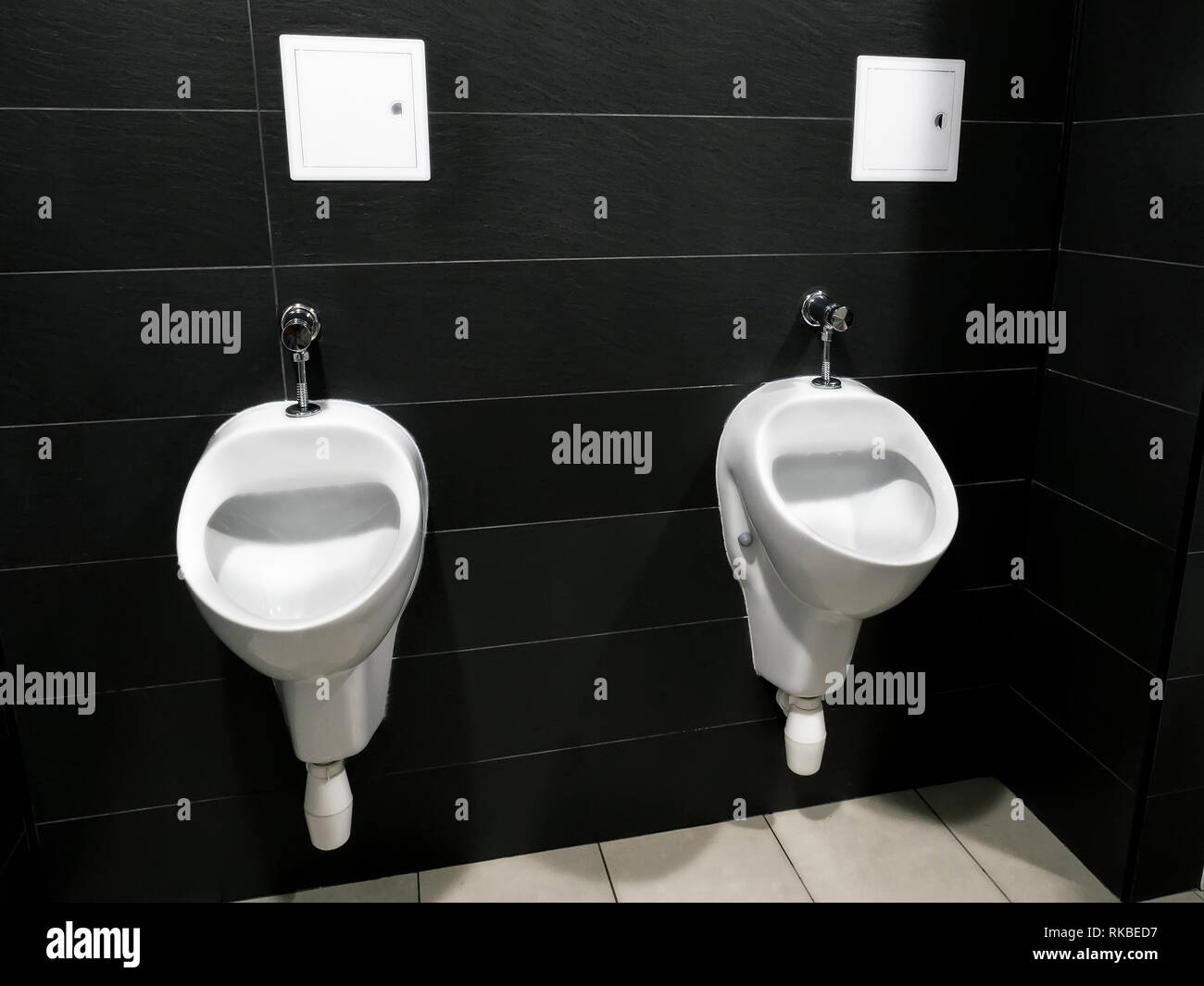 Close up row of urinal toilet blocks in public restroom clean blue ...