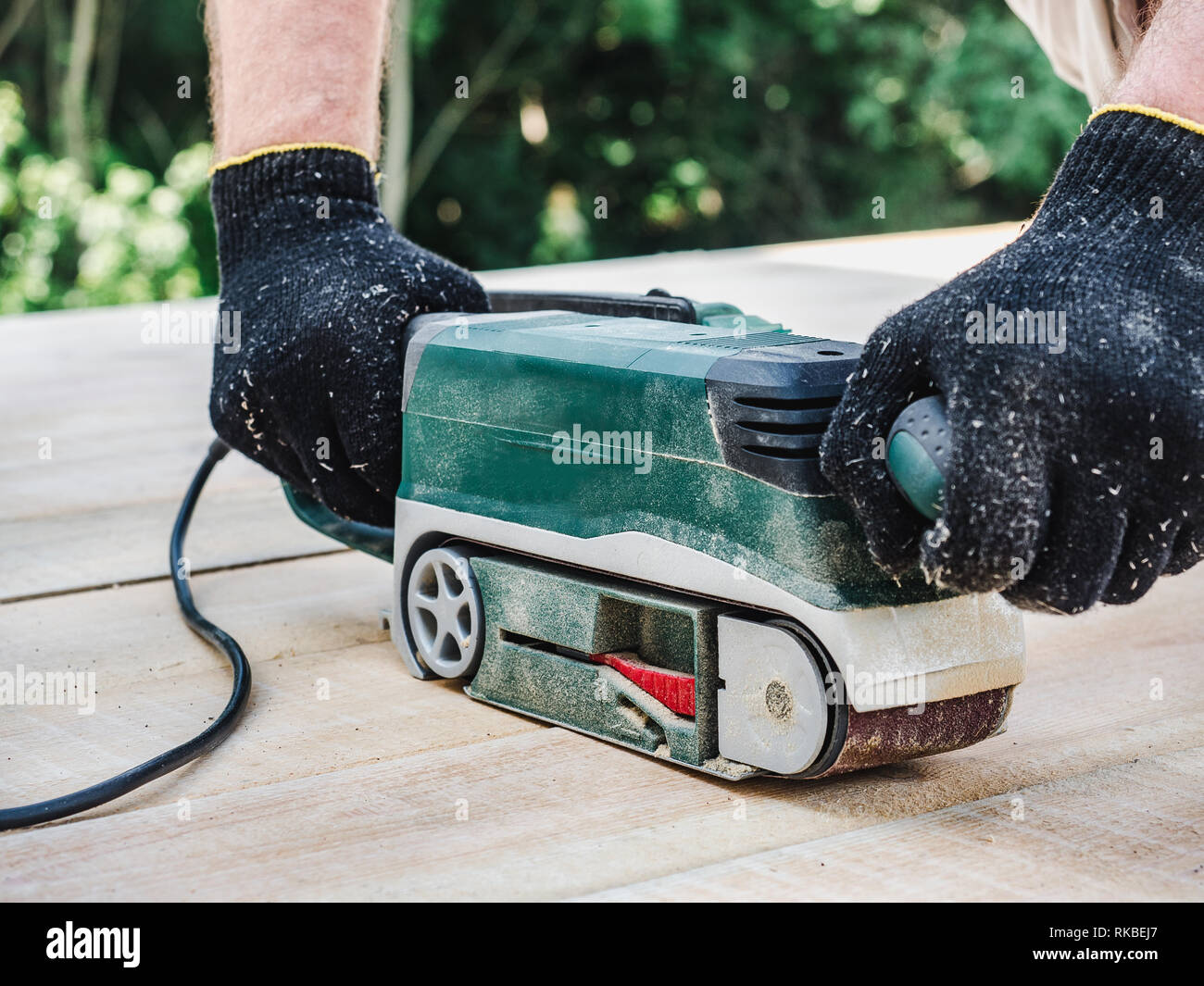 Strong men's hands and a machine for working with wood Stock Photo - Alamy