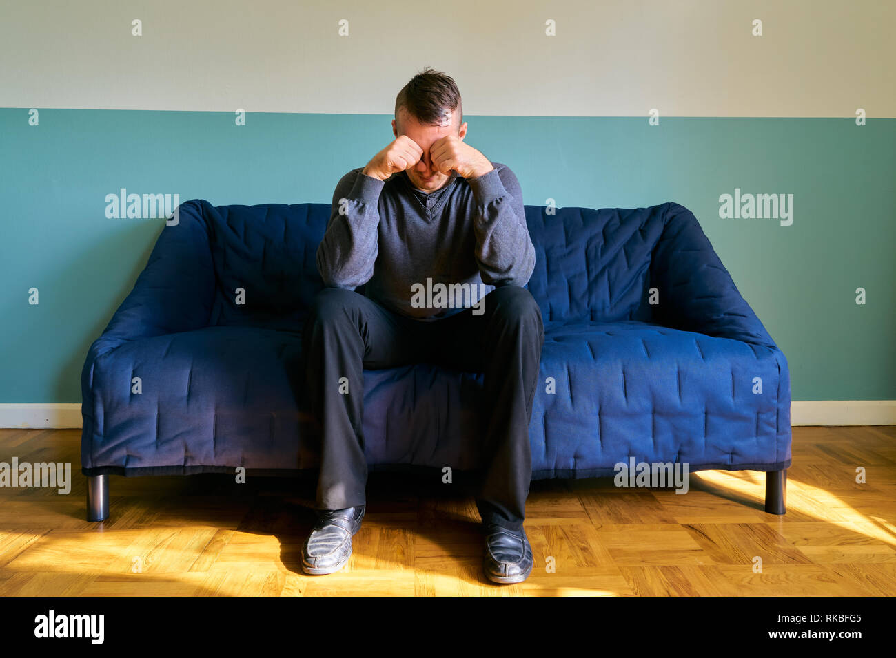 Handsome guy posing - crying man sitting on the sofa worried and ...
