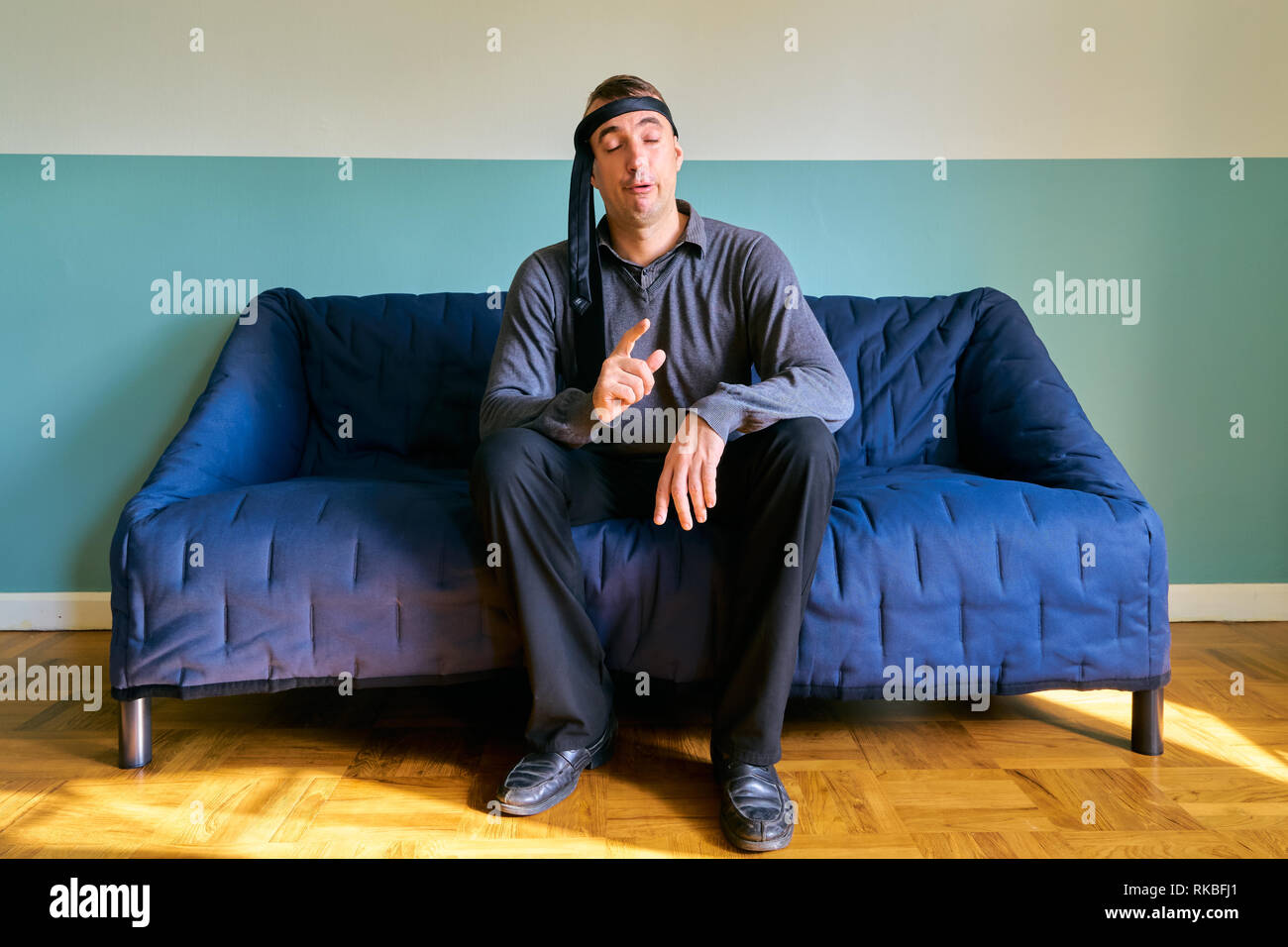 Handsome guy posing - crazy man making a face sitting on the sofa and ...