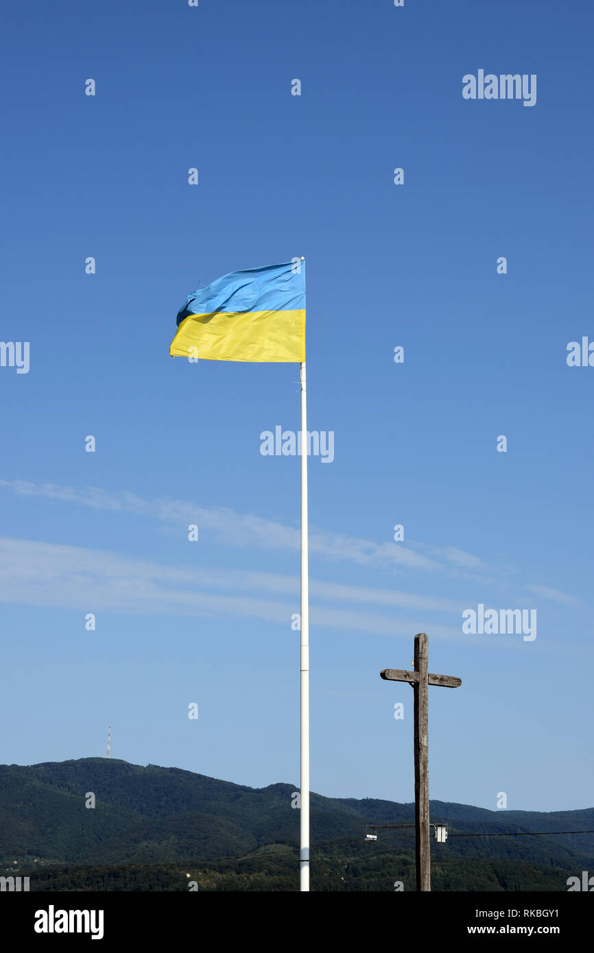 Ukraine flag and christian cross, Khust city background. View from ruin ...
