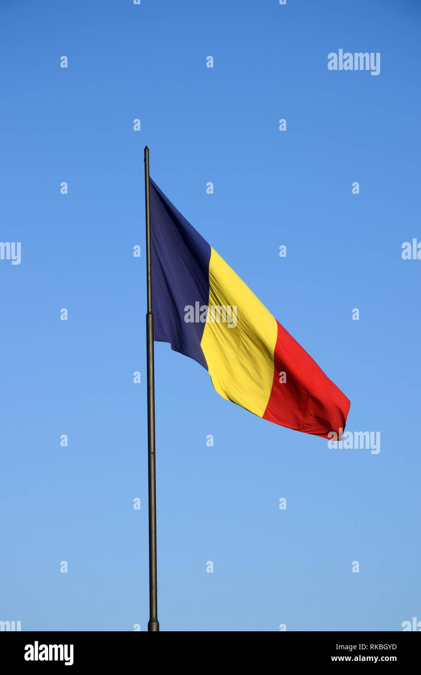 Romanian flag waving in the wind in front of a clean blue sky. Romania ...