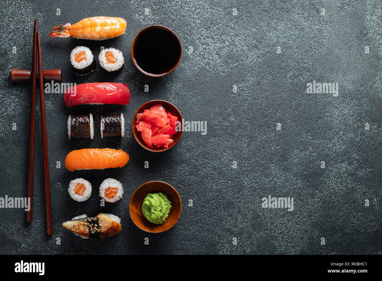 Set of sushi and maki on dark stone table. Top view with copy space ...