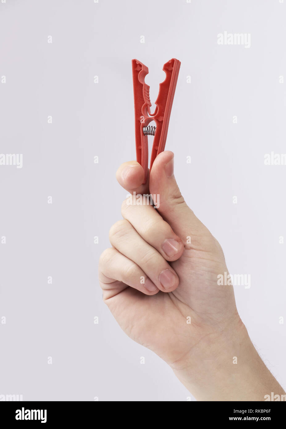 closeup. hand holding a clothespin isolated on a white background Stock ...
