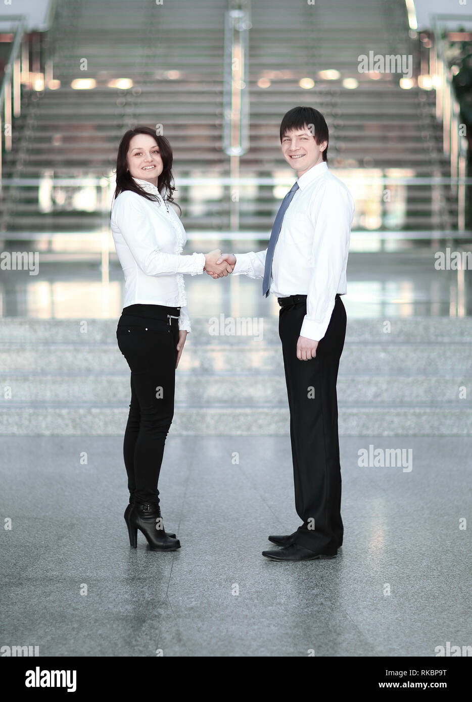 welcome handshake of young business partners on the background of the office Stock Photo - Alamy