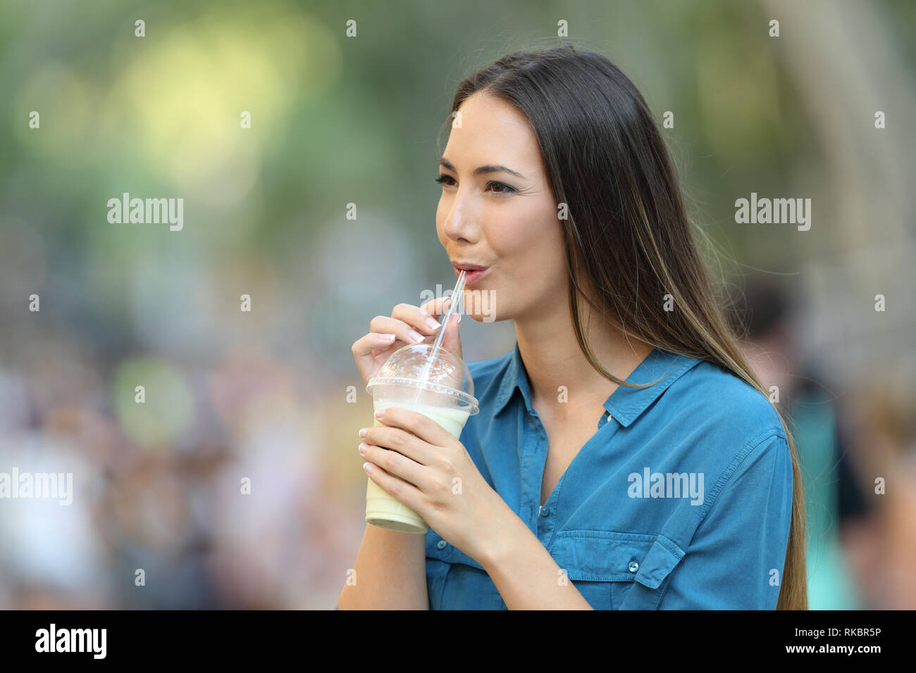 Woman holding smoothie walking hi-res stock photography and images - Alamy