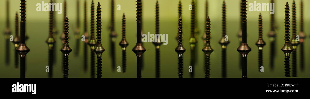 Screws macro photo, yellow background, metal screw Stock Photo - Alamy