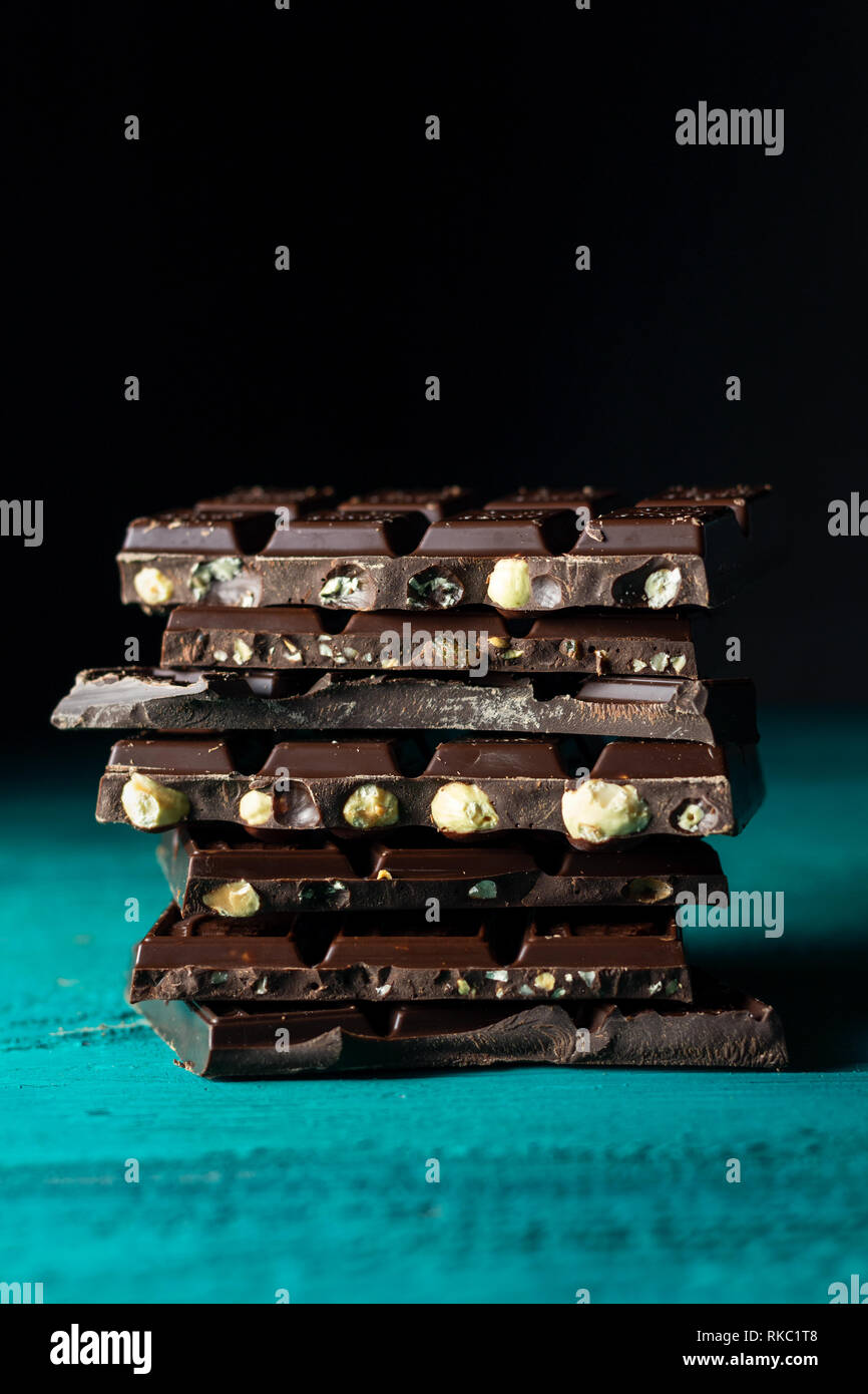 A stack of chocolate bars on a teal wooden backdrop Stock Photo - Alamy