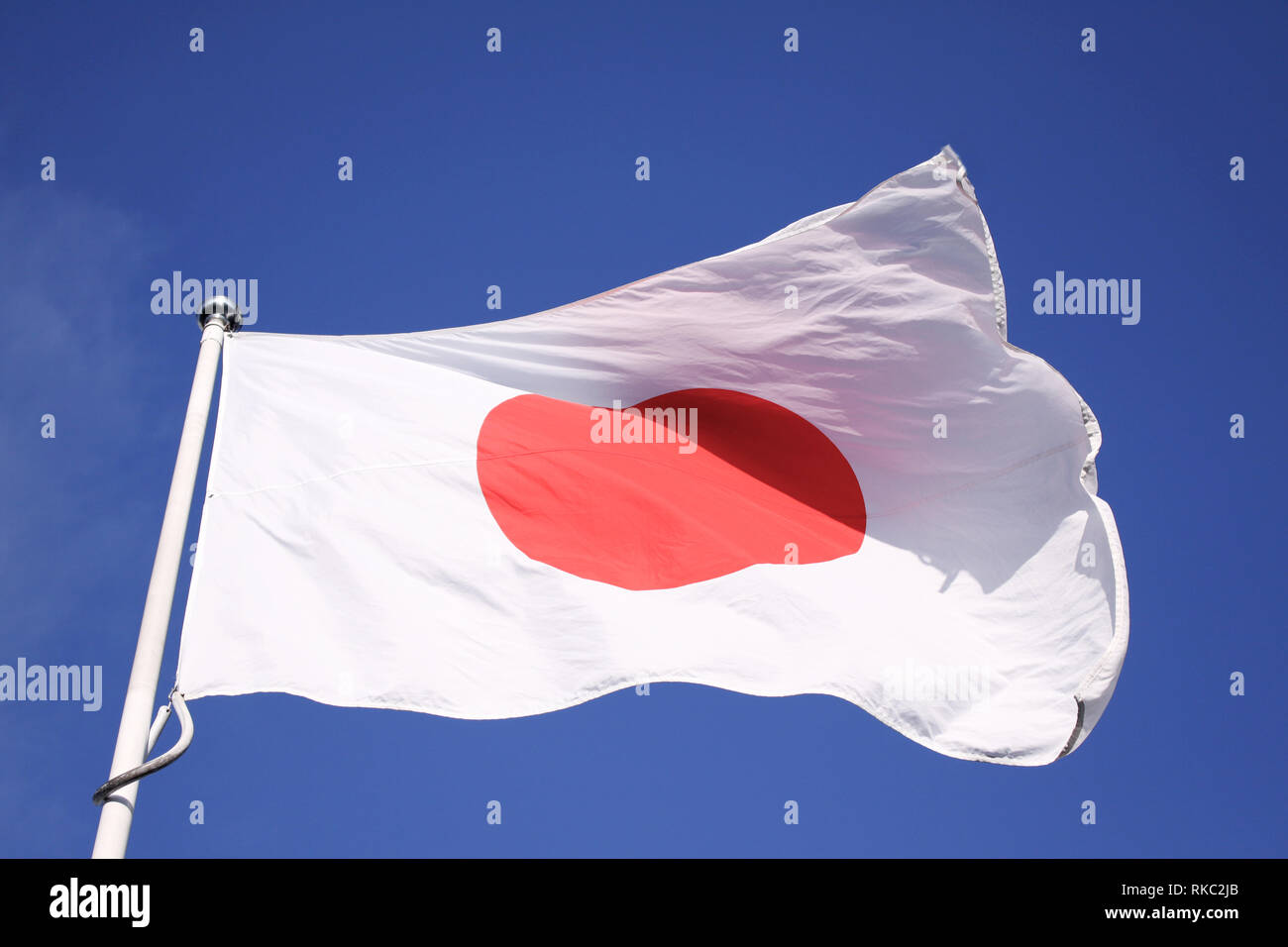 Japan flag waving on the wind with background of blue sky Stock Photo ...