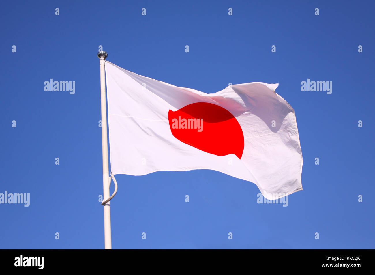Japan flag waving on the wind with background of blue sky Stock Photo ...