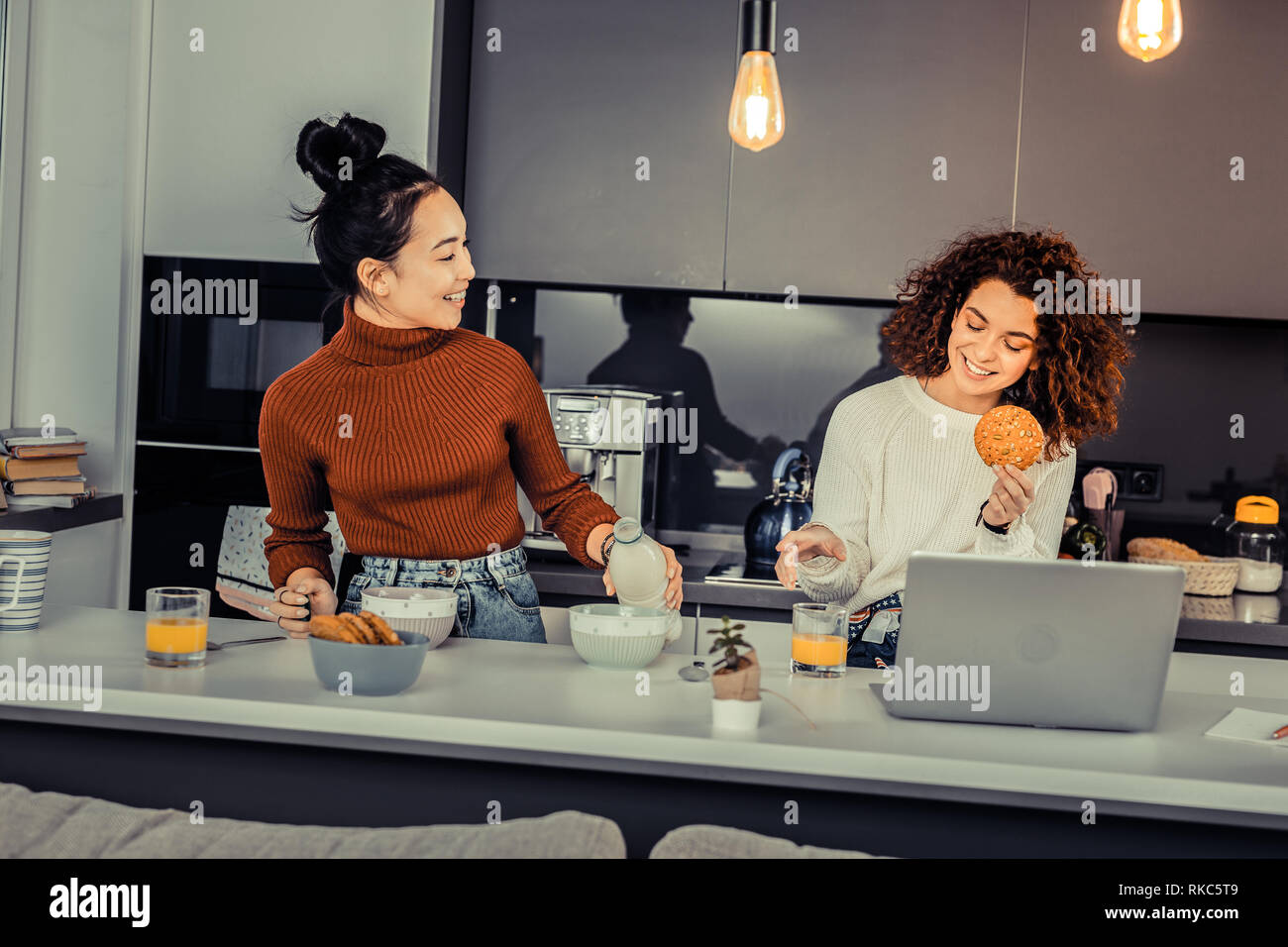 Two friends making cereals with milk in the morning Stock Photo - Alamy