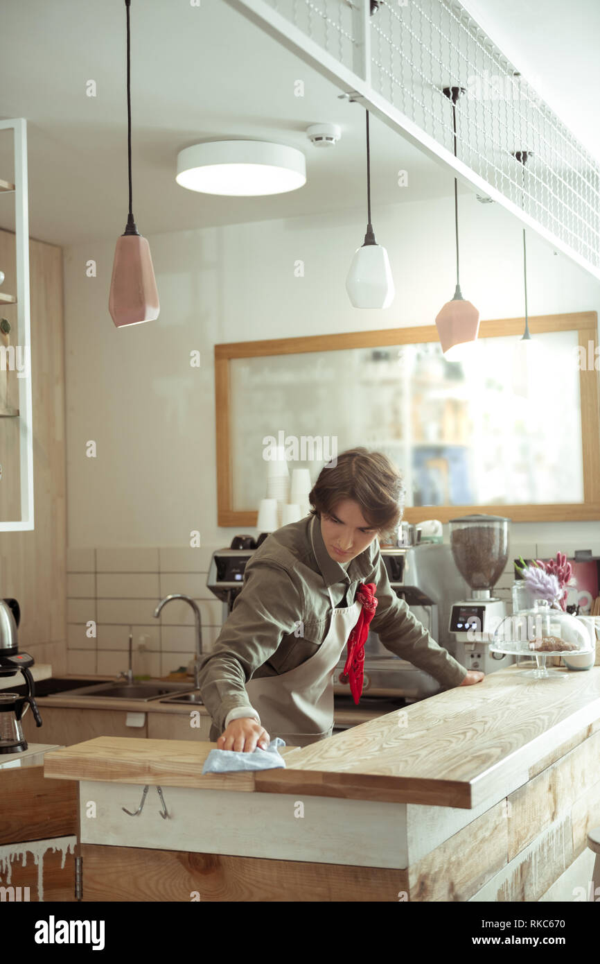 Precious young man in grey apron wiping details of coffee machine Stock ...