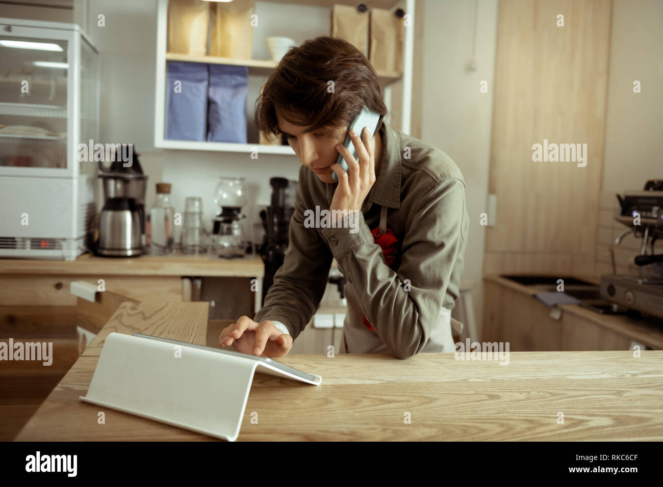Busy dark-haired guy working with program on white tablet Stock Photo ...