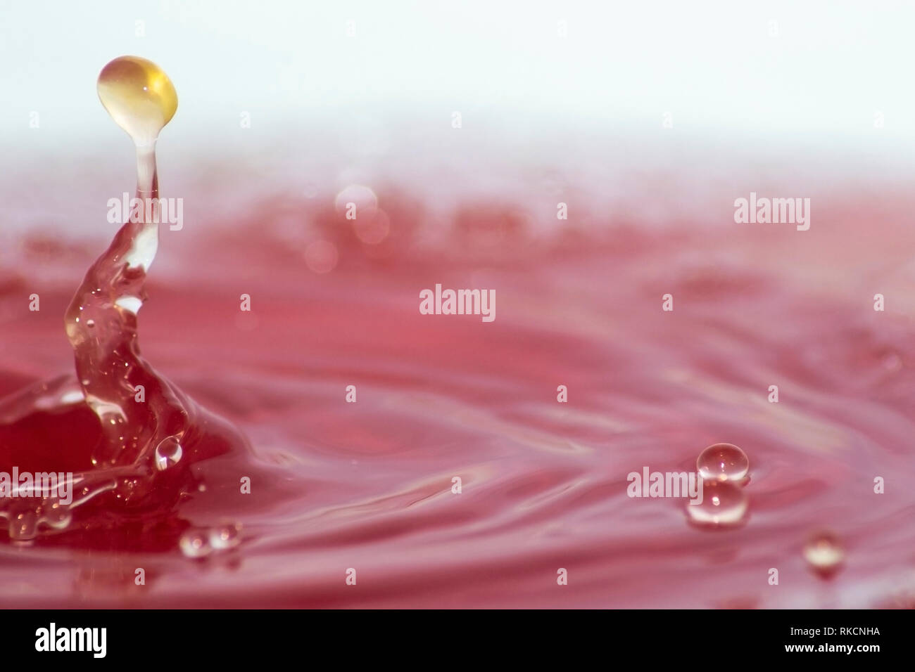 Close up of a water drop landing in pink water Stock Photo - Alamy