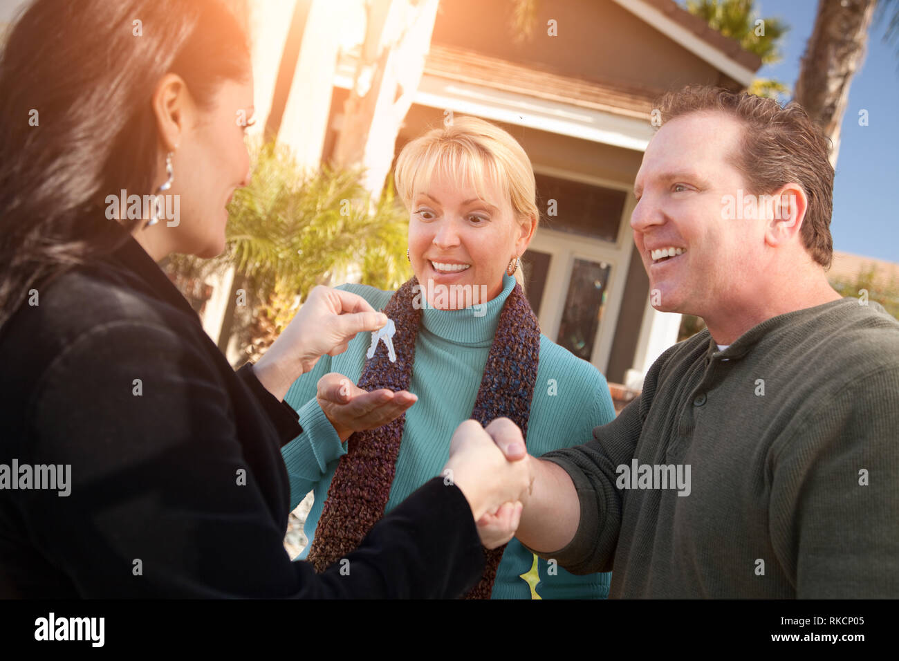 Hispanic Female Real Estate Agent Handing Over New House Keys to Happy ...