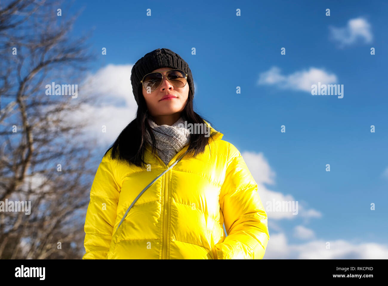 A Chinese woman wearing a yellow winter jacket looking at the camera on ...