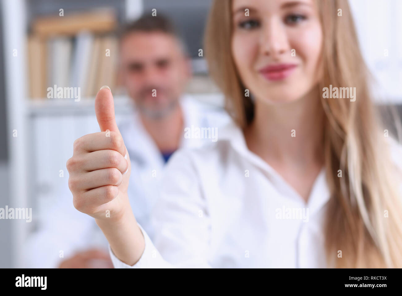 Woman show ok or confirm with thumb up Stock Photo - Alamy