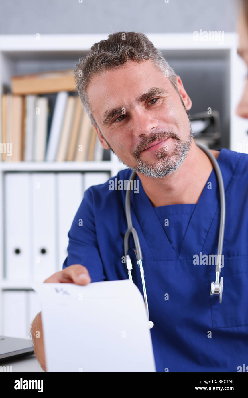 Male medicine doctor in blue uniform hold and give prescription Stock ...