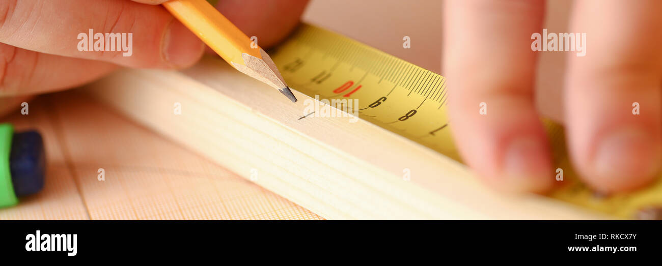 Arms of worker measuring wooden bar Stock Photo - Alamy