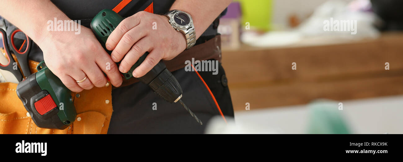 Arms of worker using electric drill Stock Photo - Alamy