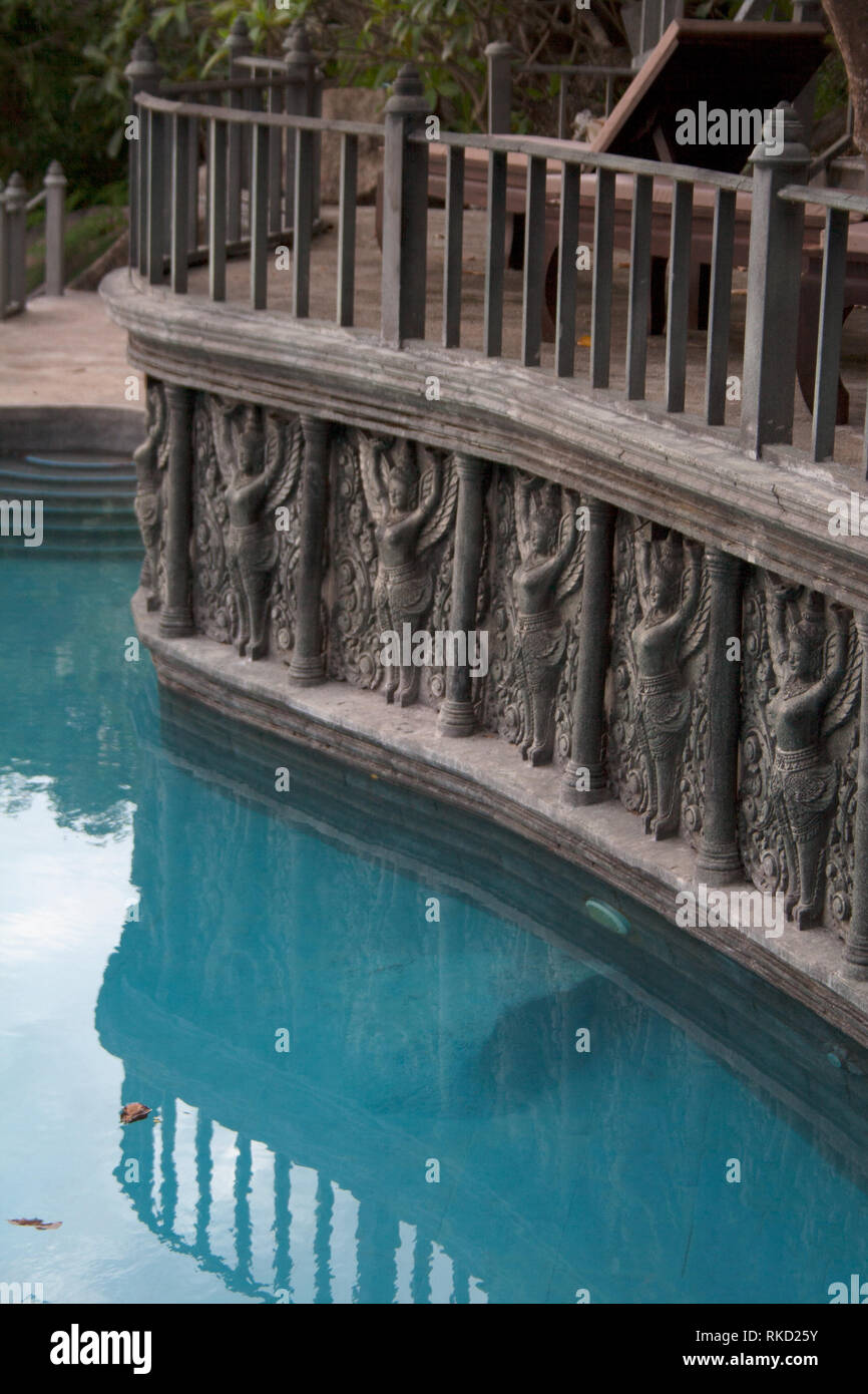 Garden lounge pool surrounded by stone sculptures and pilasters with a ...