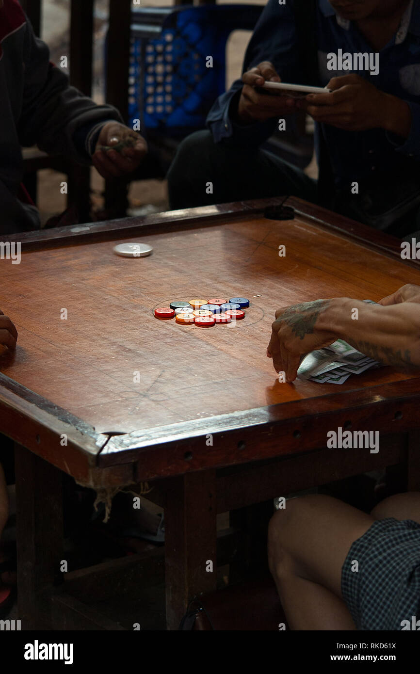 Asian men play the popular table top came of carrom, Mandalay, Myanmar ...