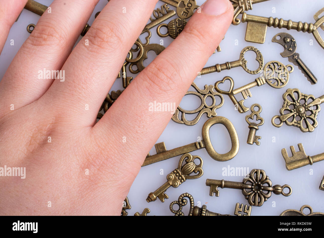 Hand and retro style metal keys on a white background Stock Photo - Alamy