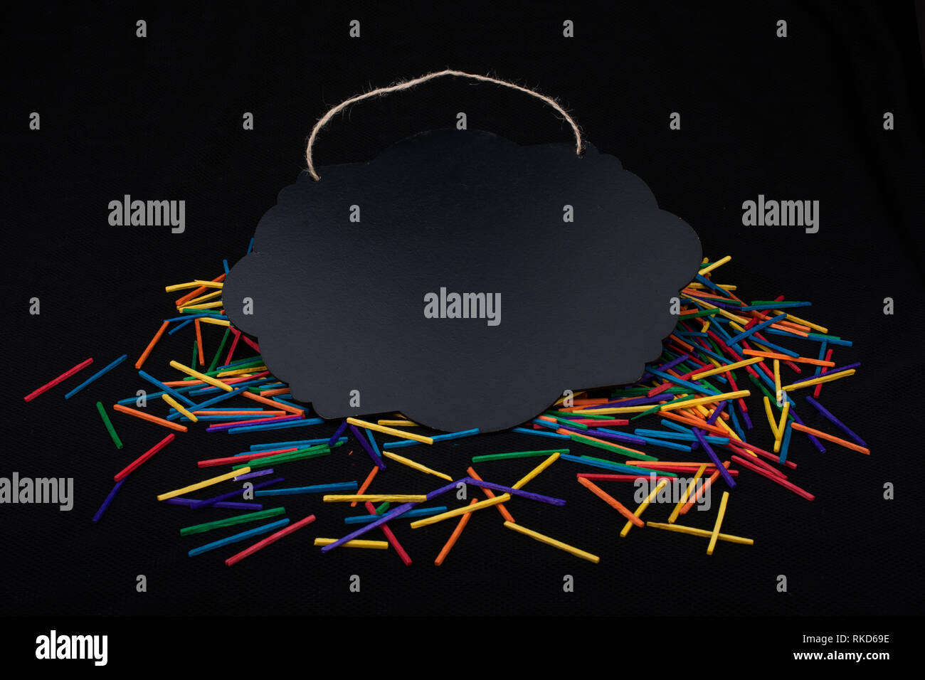 Black speech bubble shaped notice board on colorful sticks on black ...