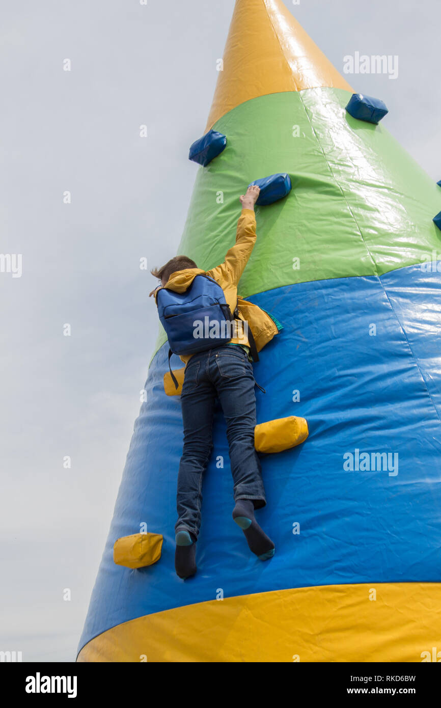 A boy climbing on cone shaped climbing course Stock Photo - Alamy