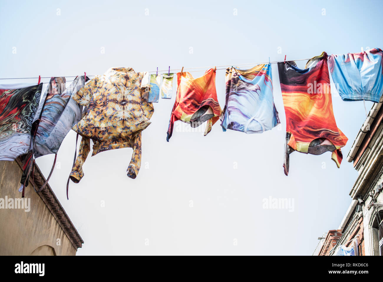 Clothes hanging from a clothes line rope in the street Stock Photo - Alamy