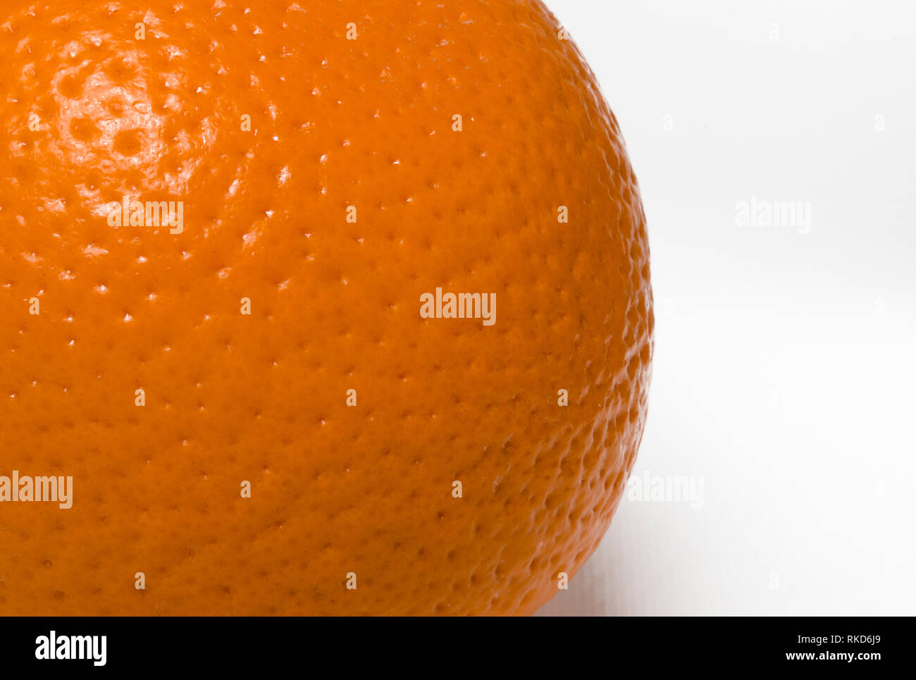 Juicy orange with textured skin closeup lies on a white background with ...