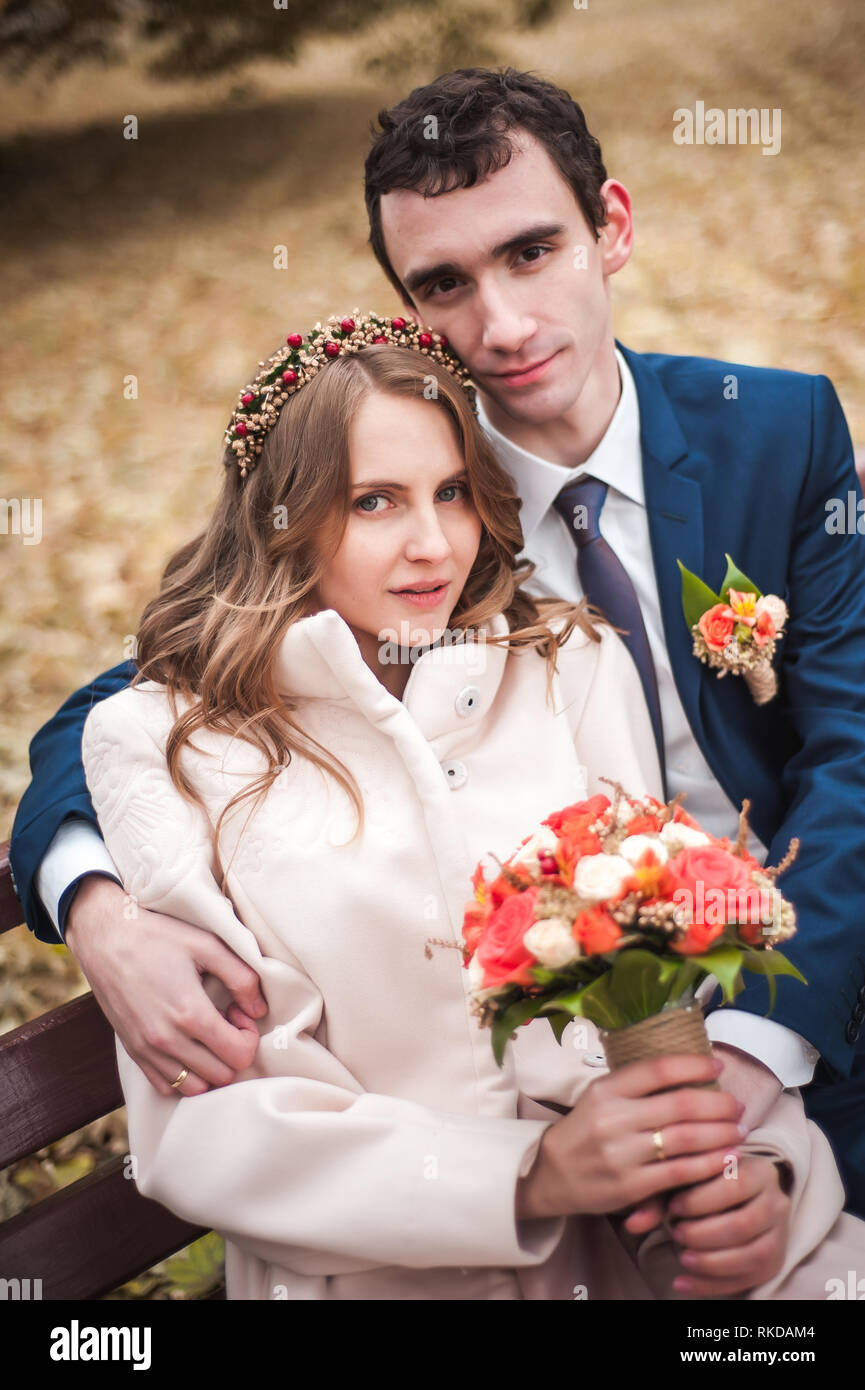 The beautiful bride and handsome groom sitting on a bench in the Stock ...