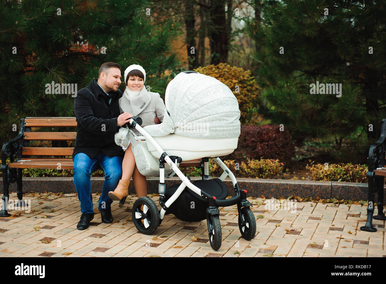 Family walk in the autumn park with a pram. Mom, dad and baby Stock ...