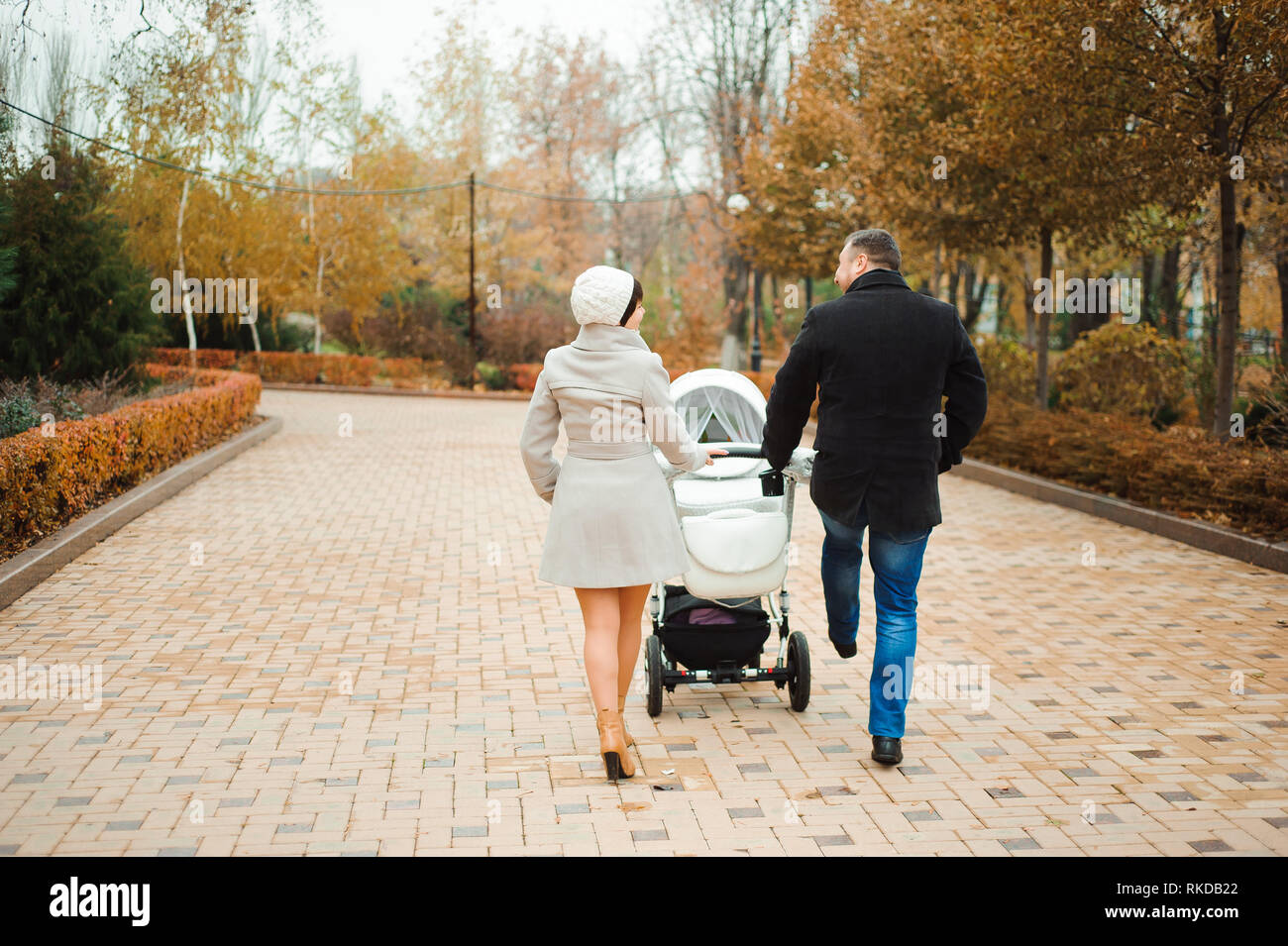 Family walk in the autumn park with a pram. Mom, dad and baby Stock ...